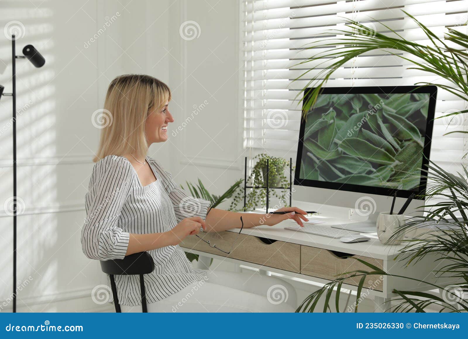 Woman Working on Computer at Table in Room. Interior Design Stock Photo ...