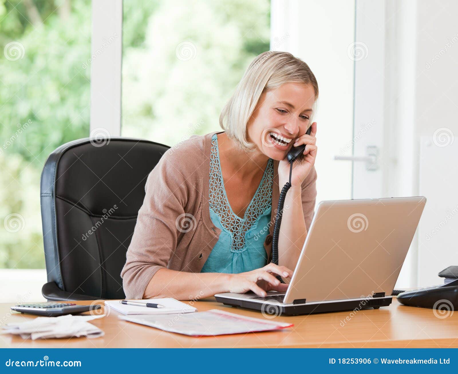 Woman Working on Her Computer while she is Phoning Stock Photo - Image ...