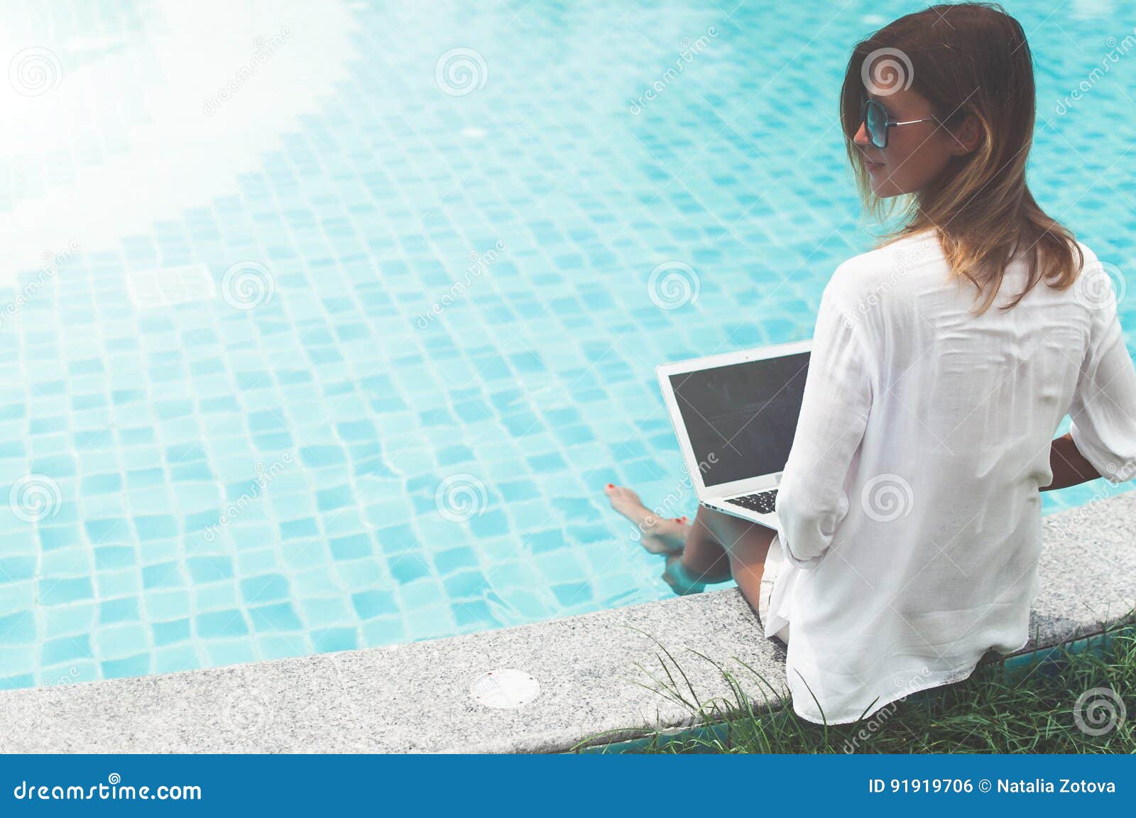 Woman Working on Her Laptop Computer Sitting at Poolside Stock Photo ...