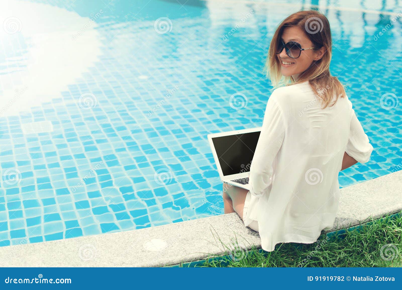 Woman Working on Her Laptop Computer Sitting at Poolside Stock Photo ...