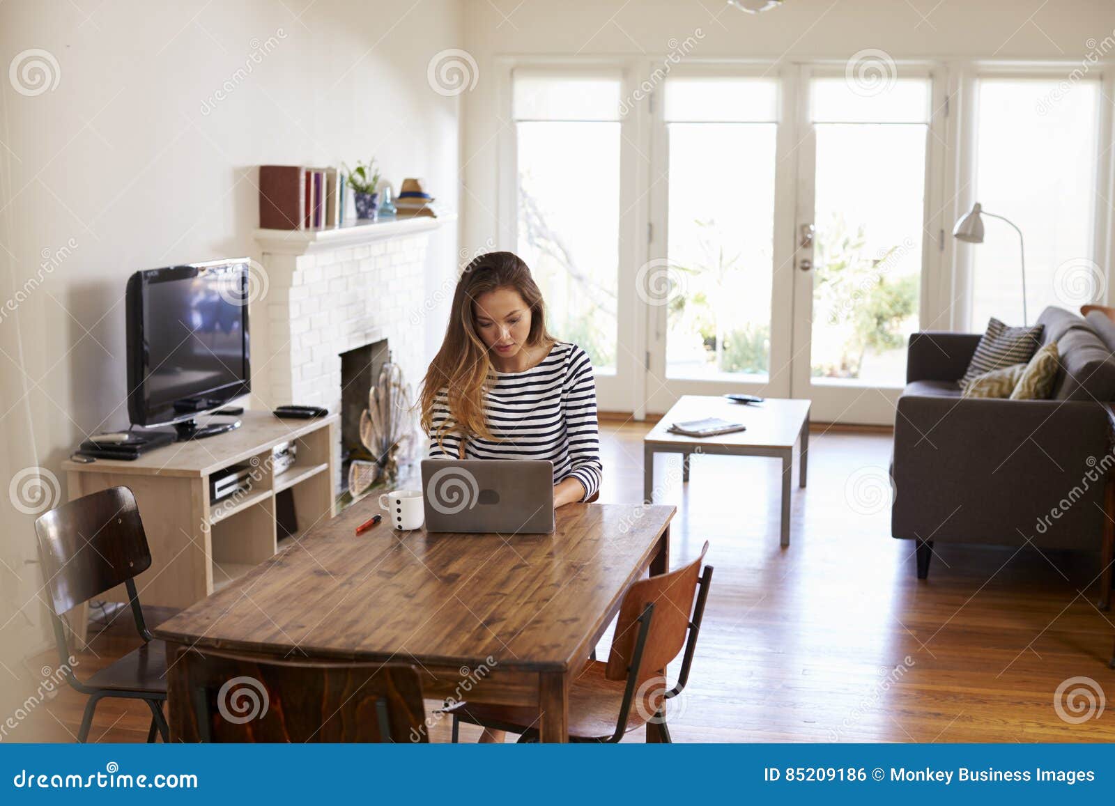 Woman Working from Home Using Laptop on Dining Table Stock Photo ...