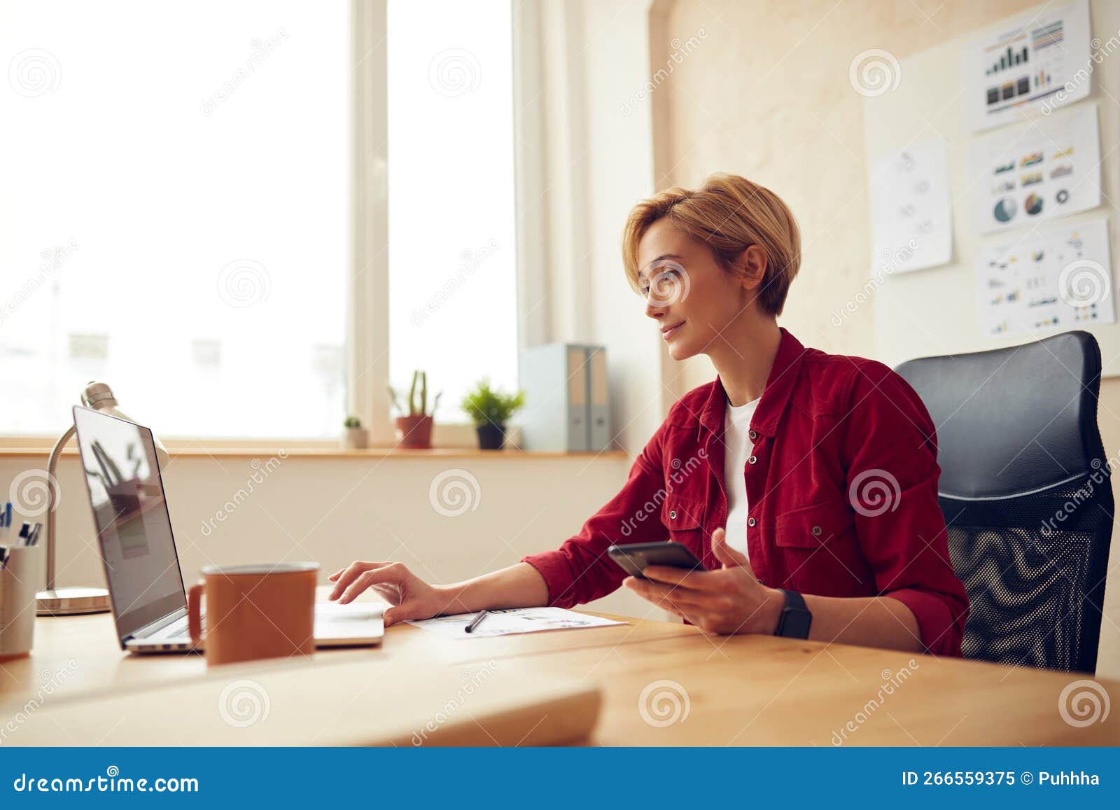 Woman Working Laptop at Office. Positive Lady Holding Mobile Stock ... Woman Working Laptop at Office. Positive Lady Holding Mobile Stock ...