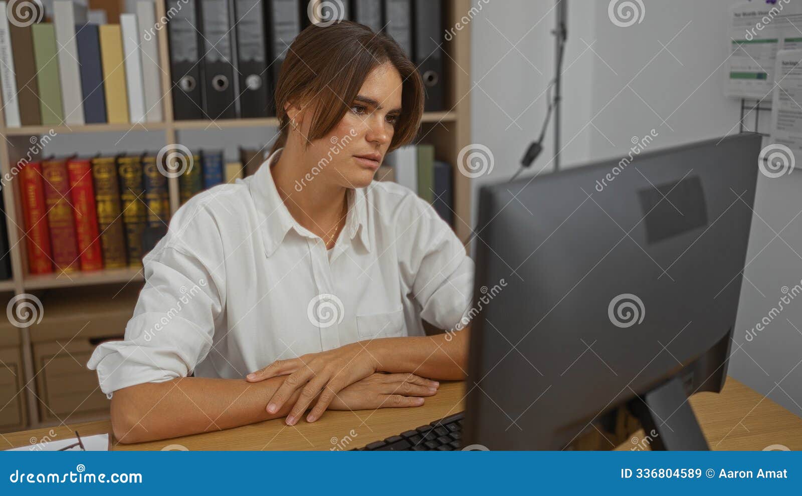 Woman Working in an Office Setting Focused on a Computer Screen with ...