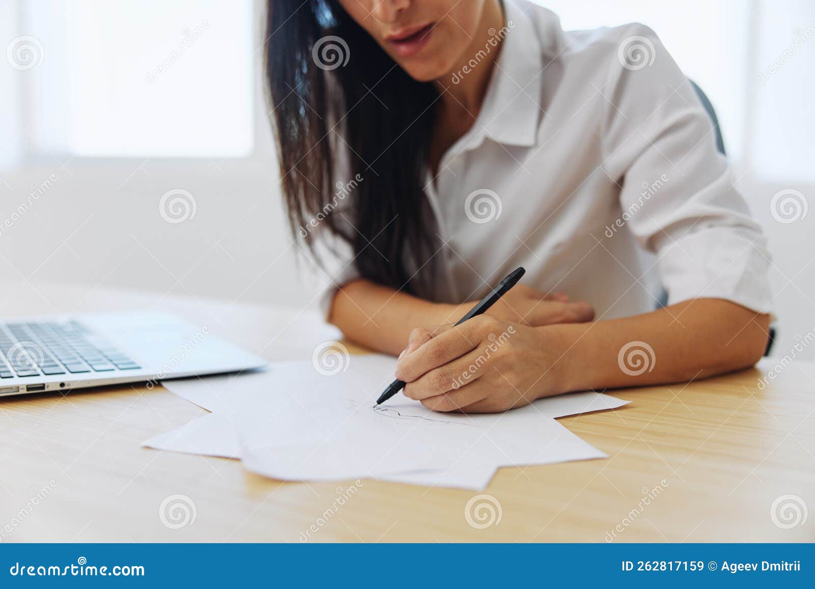 A Woman Works and Learns by Writing Down Text on Paper with a Pen and ...