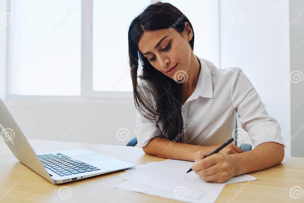 A Woman Works and Learns by Writing Down Text on Paper with a Pen and ...