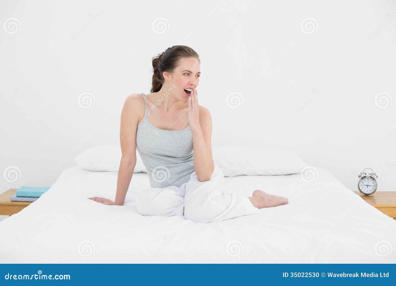 Woman yawning in bed stock photo. Image of looking, clock - 35022530