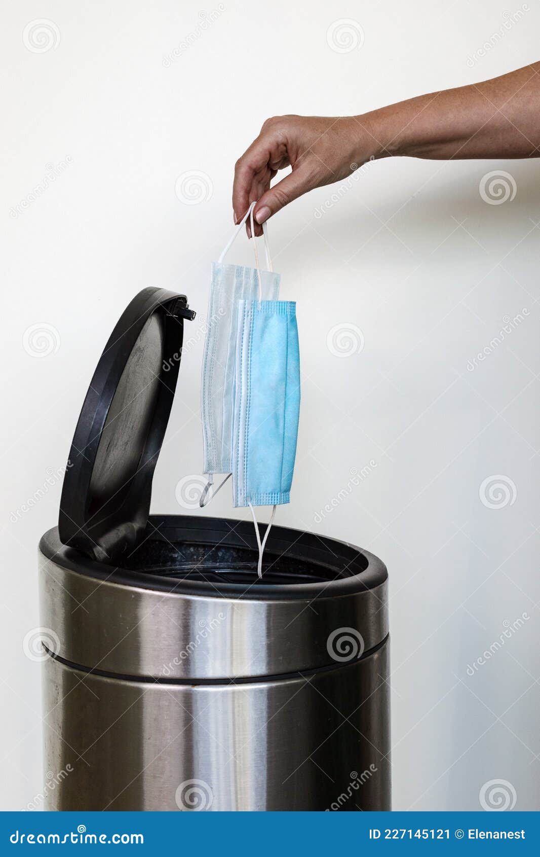 A Woman S Hand Throwing Out Medical Face Masks in a Rubbish Bin Stock ...