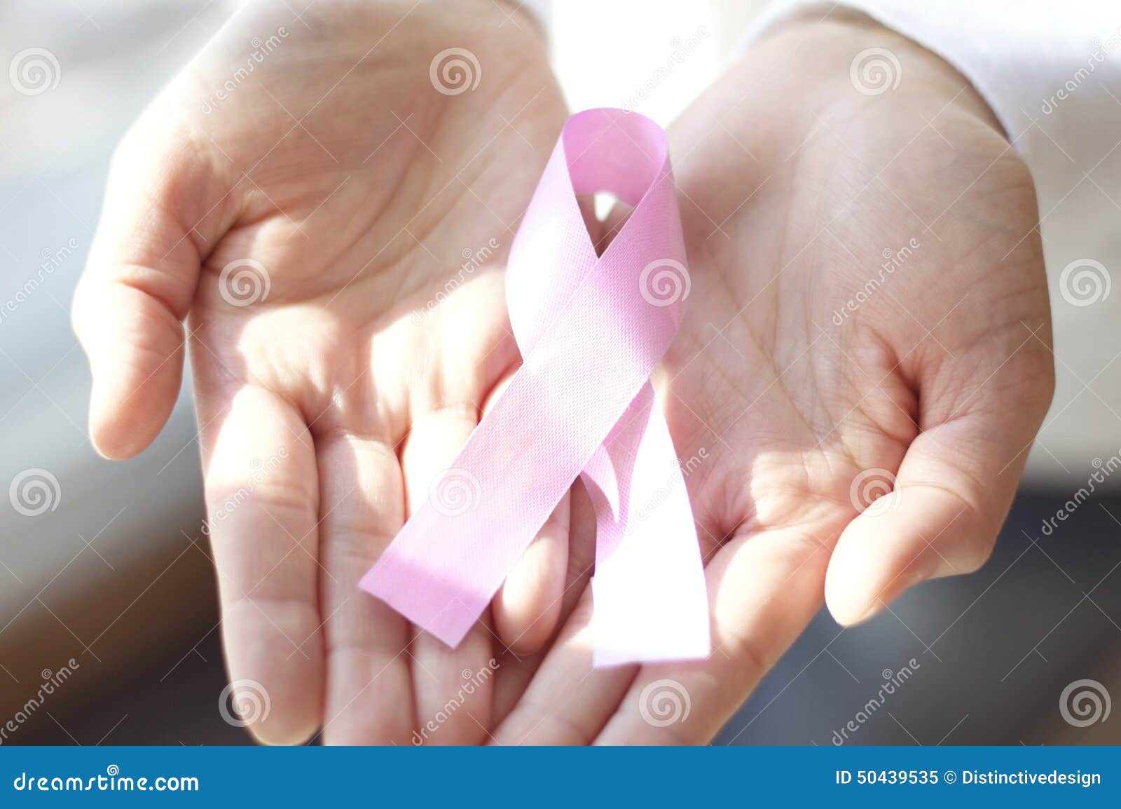 Womans Hands Holding Pink Breast Cancer Awareness Ribbon Stock Image