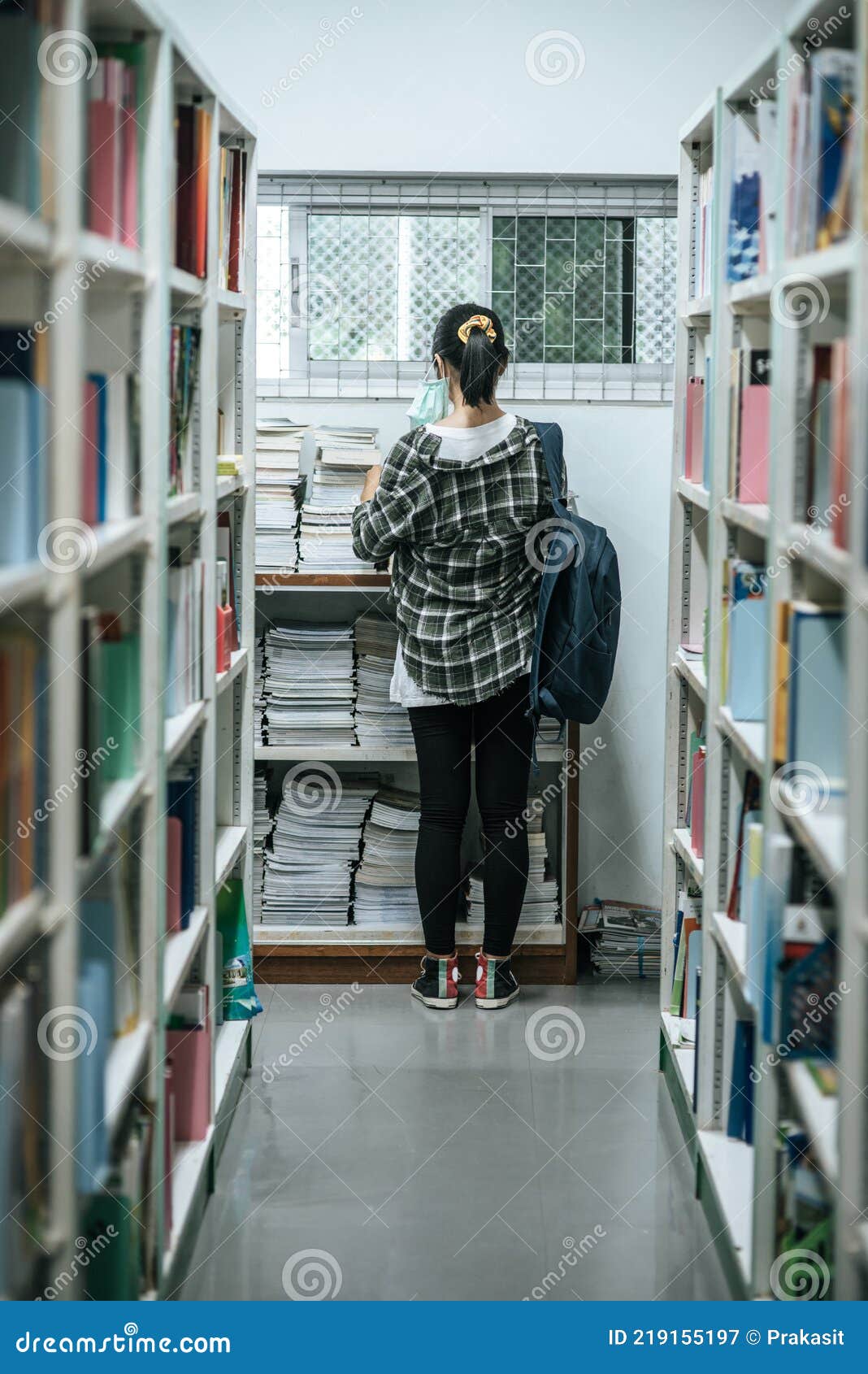 Women Carrying a Backpack and Searching for Books in the Library Stock ...