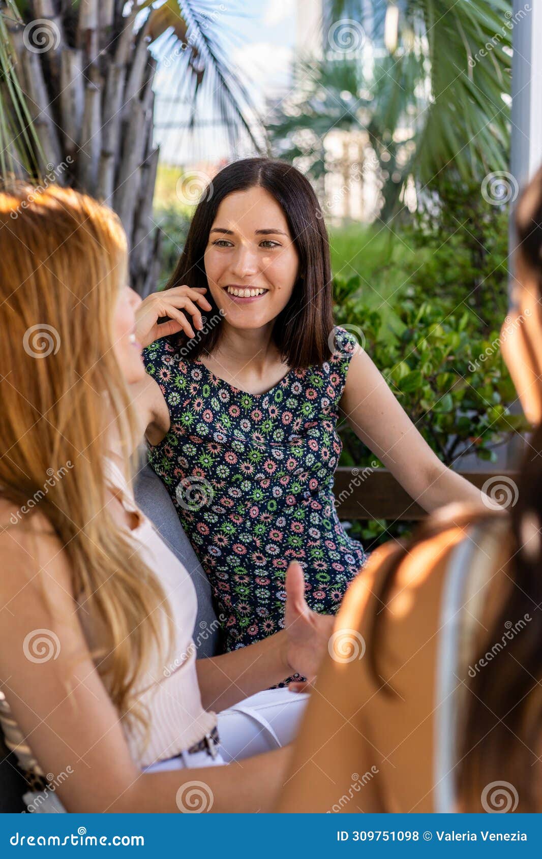 Women Friends Talking while Sitting on a Sofa in the Backyard. Vertical ...