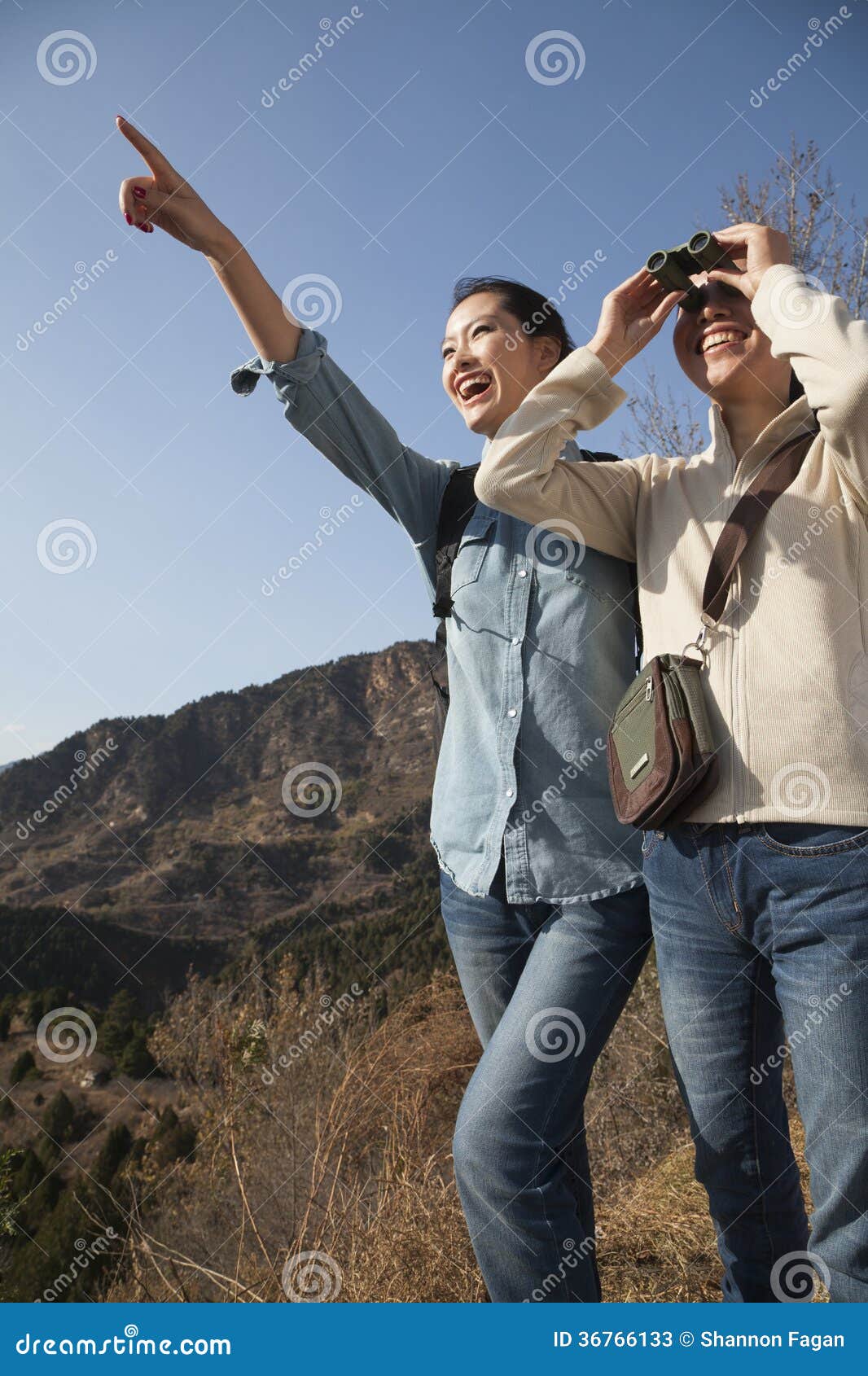 Women Hiking, Using Binoculars, Pointing at the Mountain Top Stock ...