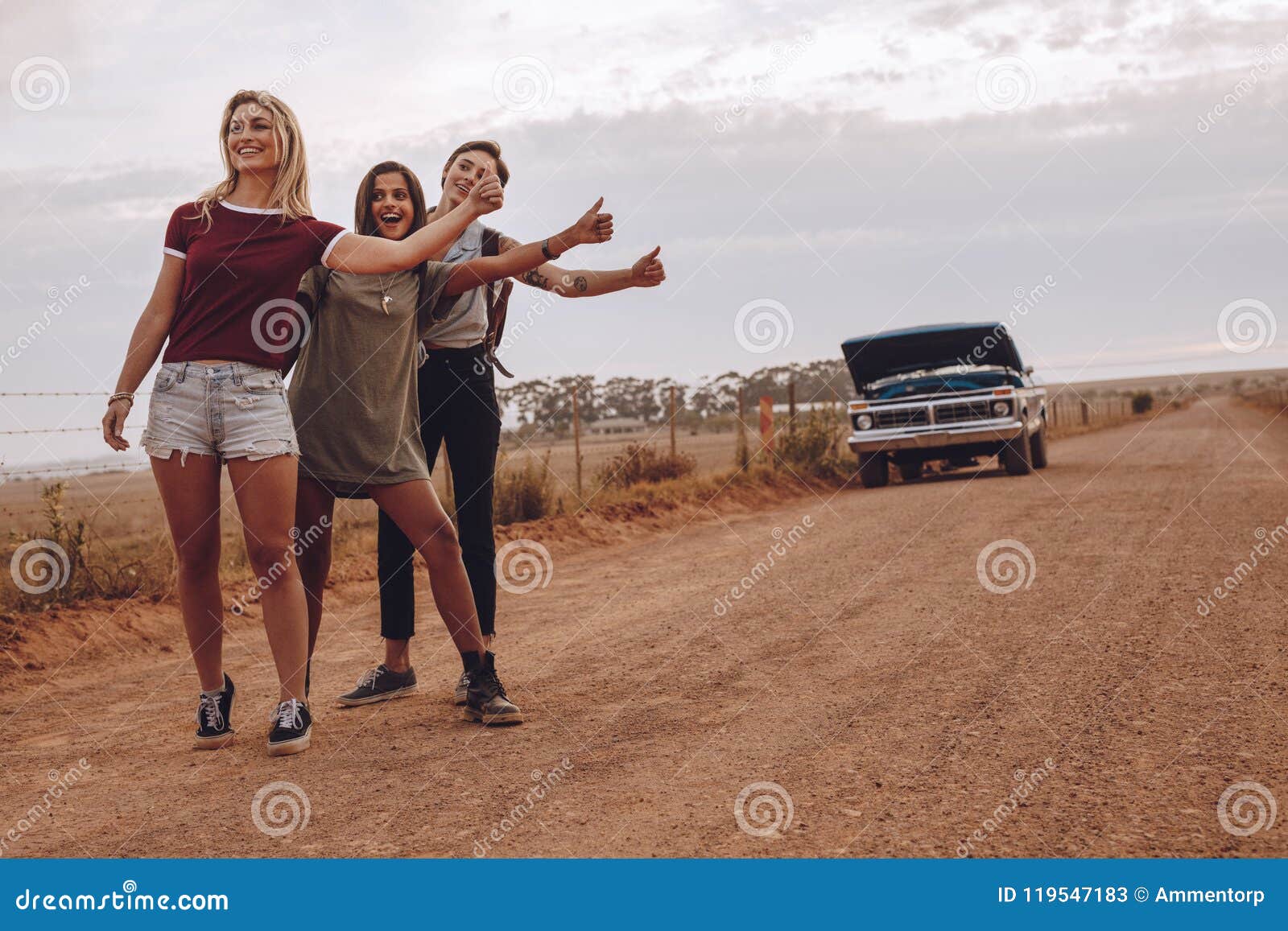 Women Hitchhiking Near Their Broken Car On Country Road Stock Image
