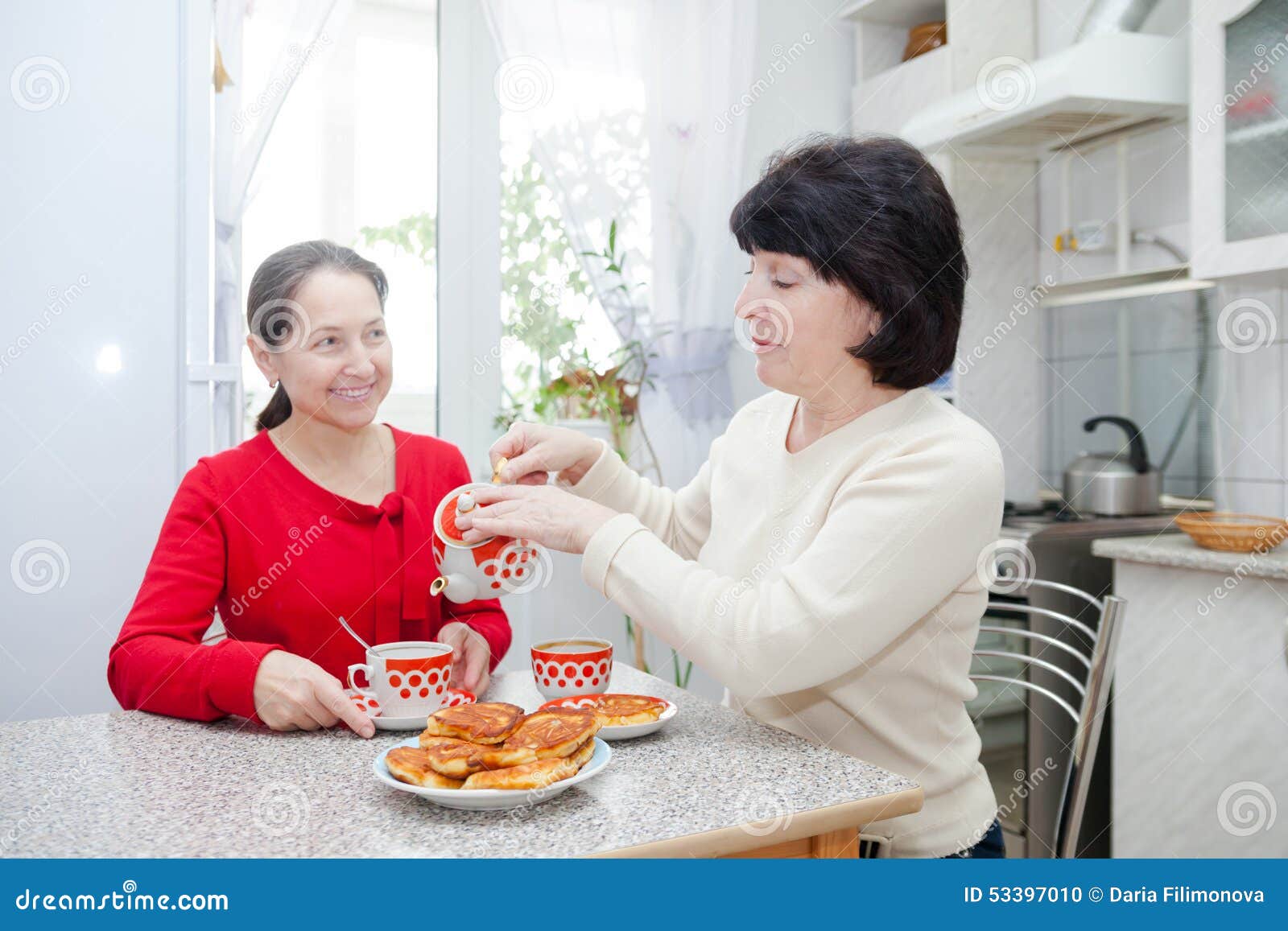 Women at Kitchen Table with Cup of Tea. Stock Photo - Image of kitchen ...