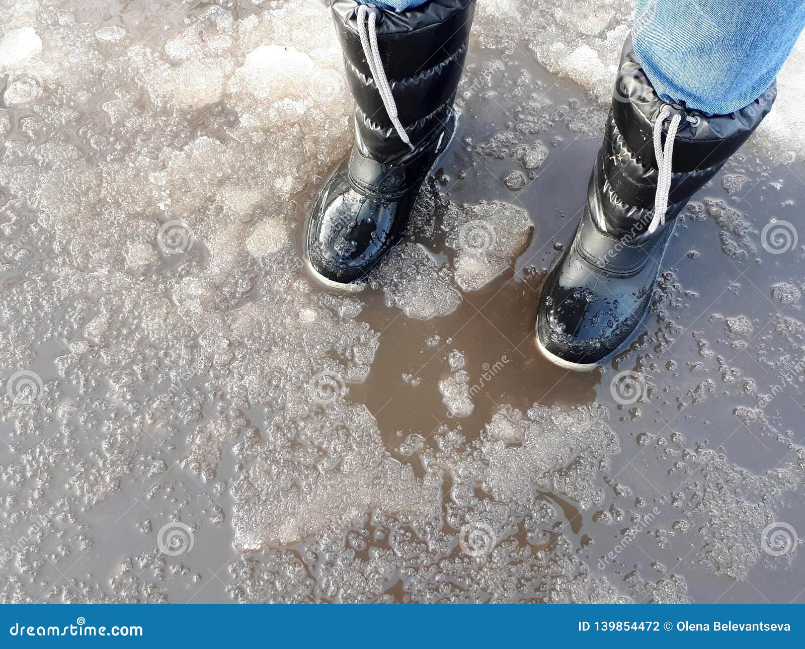 Women`s Black Rubber Boots in a Puddle in Early Spring, the Concept of ...