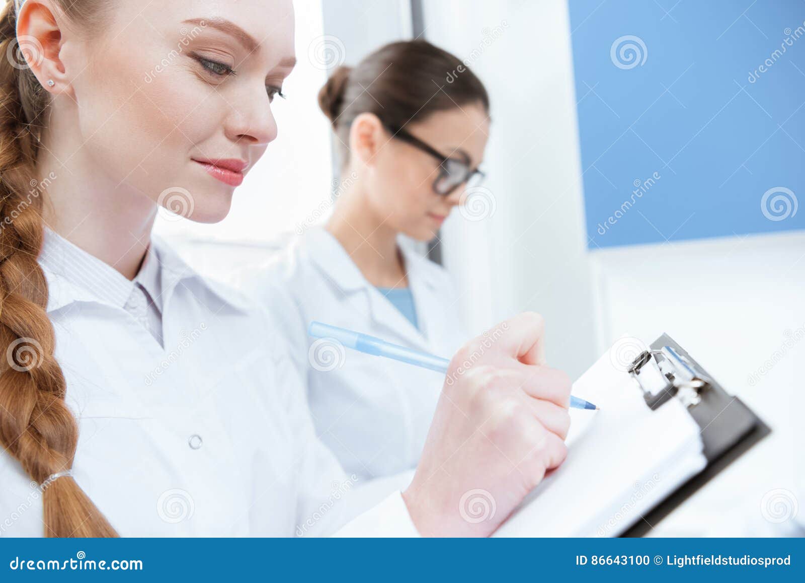 Women Scientists in White Coats Taking Notes in Laboratory Stock Photo ...