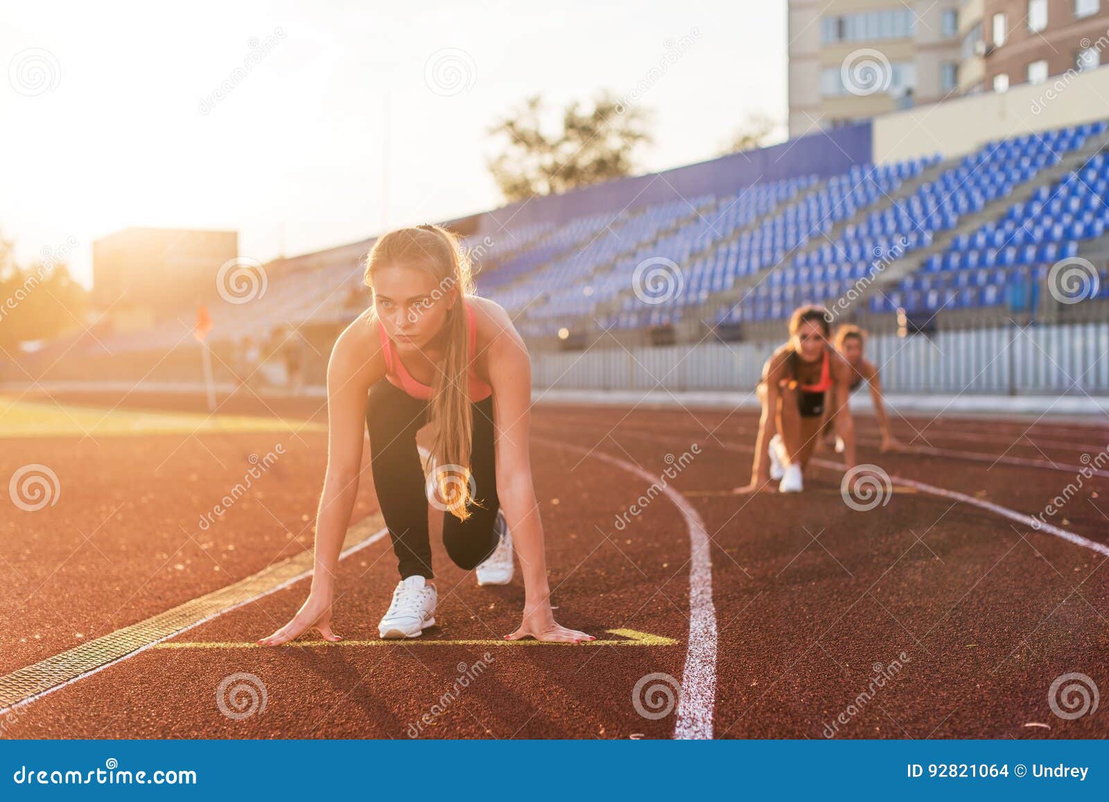 Women Sprinters at Starting Position Ready for Race on Racetrack. Stock ...