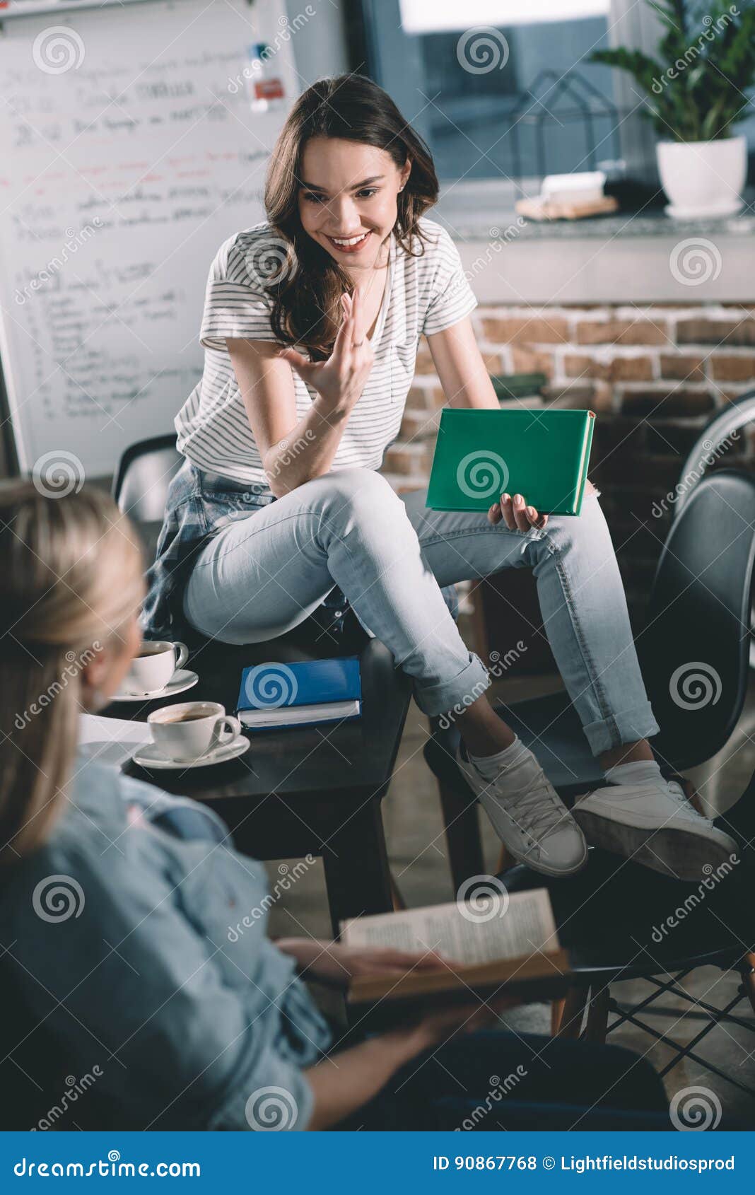 Women Students Having Conversation while Studying Together Stock Photo ...