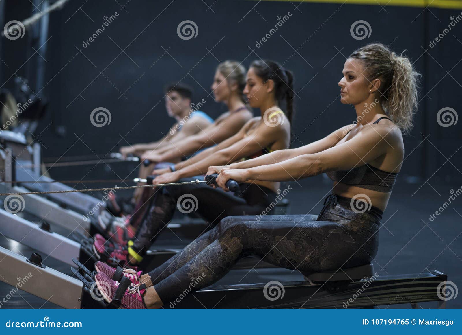 Women Training Rowing in Gym with Exercises Machines and Pull Rope ...
