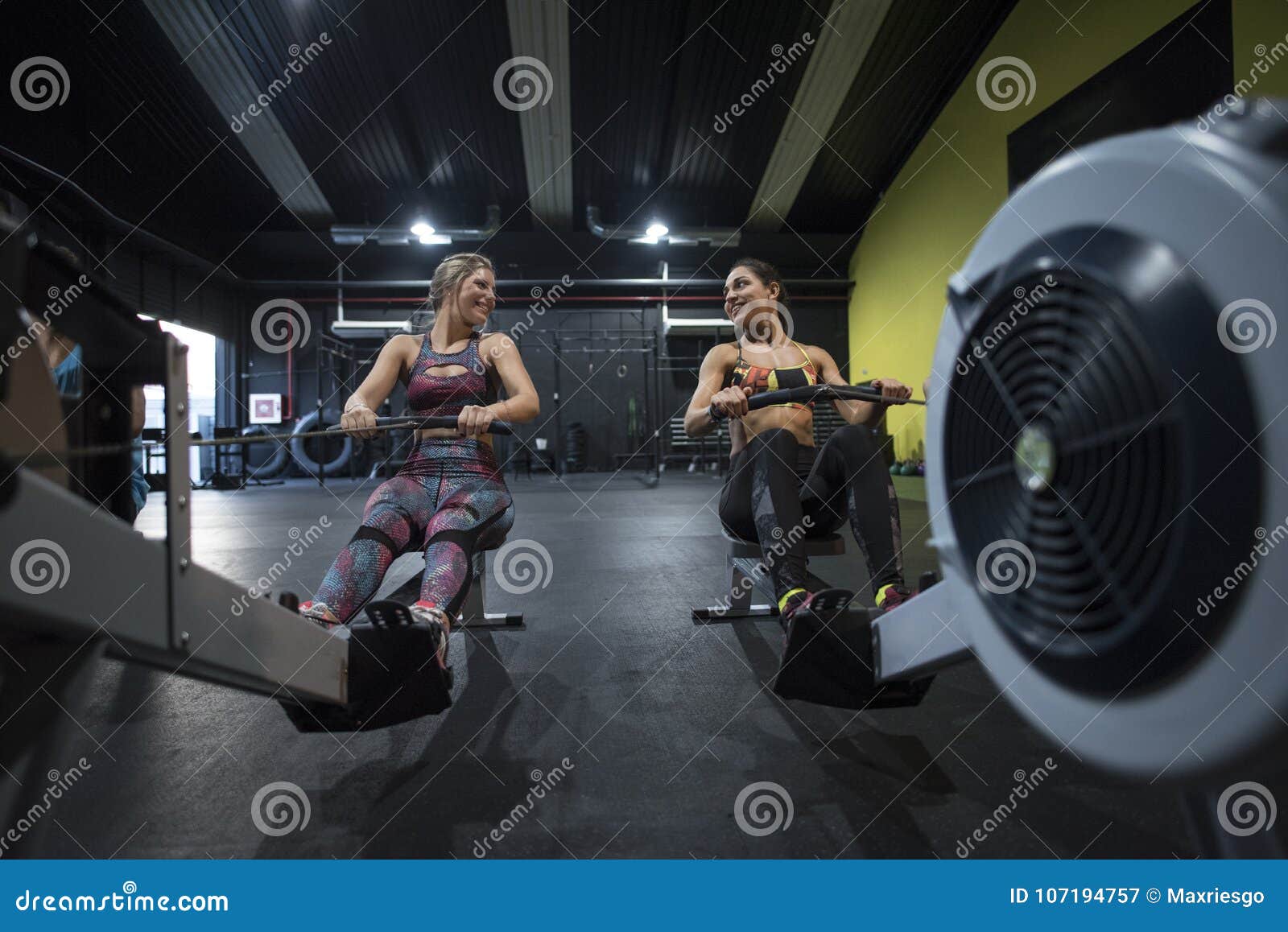 Women Training Rowing in Gym with Exercises Machines and Pull Rope ...