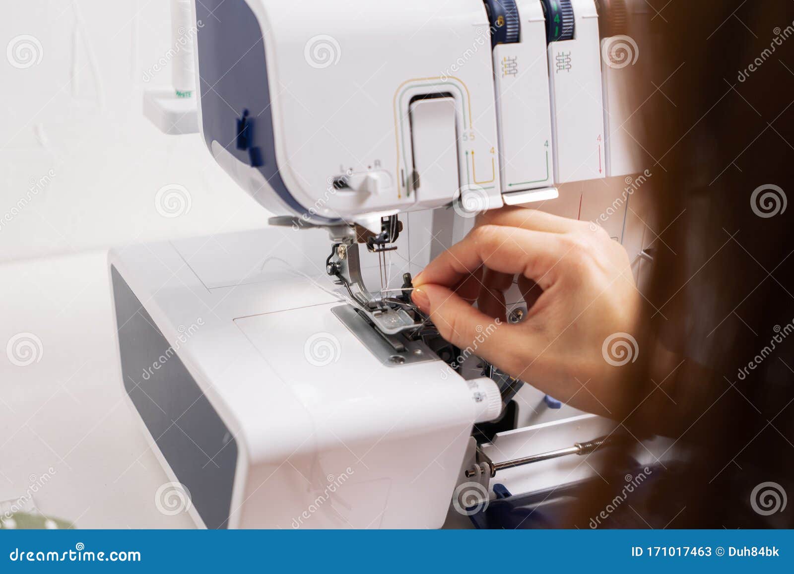 Women at Work: Girl Threading the Needle of a Sewing Machine Stock ...