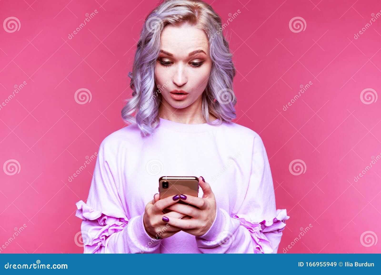 Wondered and Surprised Girl Watching Her Phone in the Pink Studio ...