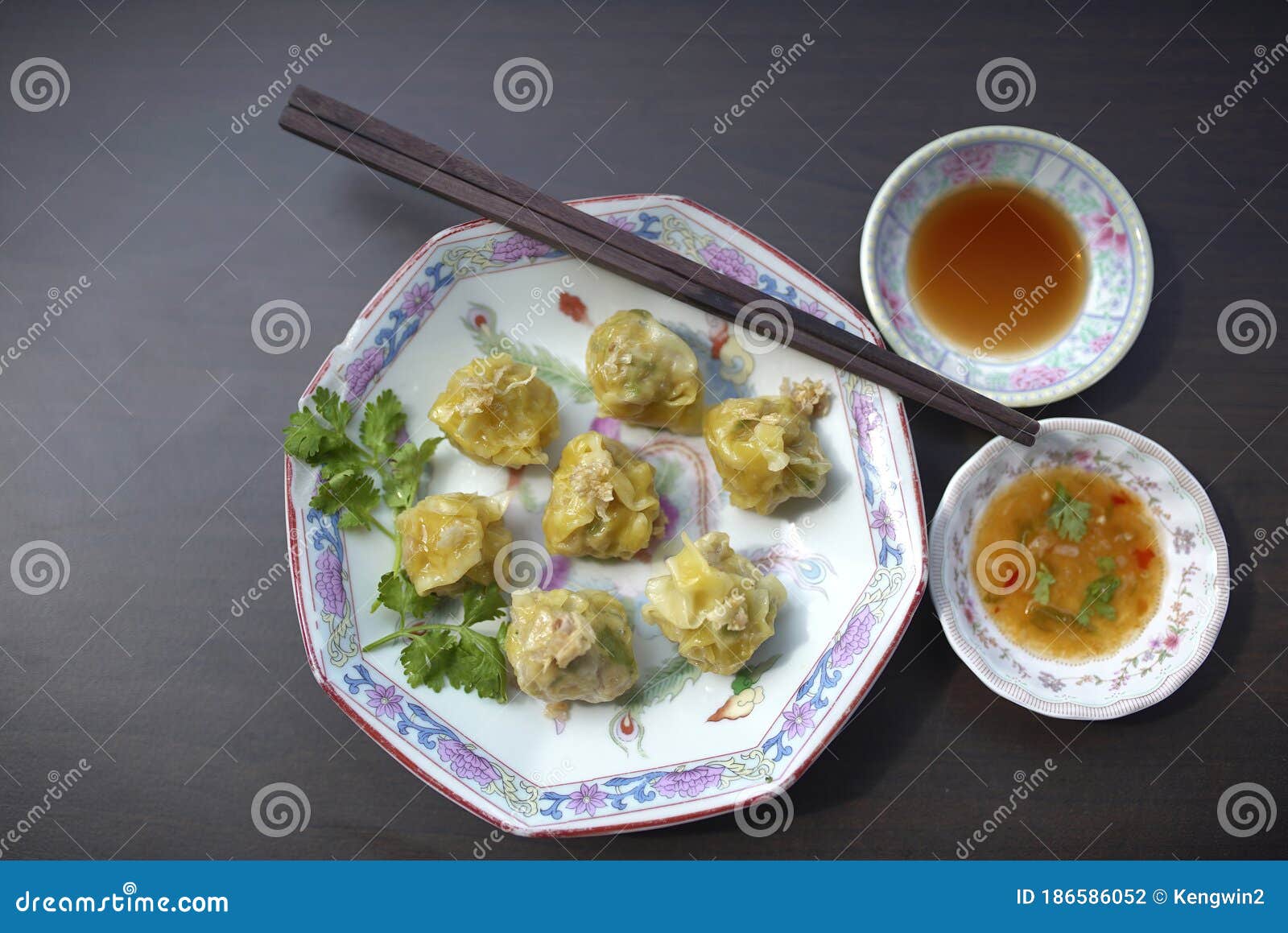 Wontons on Plate and Chopsticks on Brown Table. Stock Photo - Image of ...