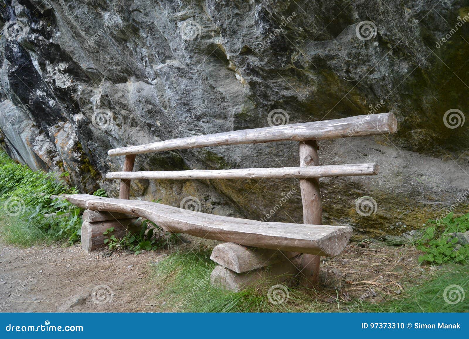 Wood bench along rocks stock photo. Image of arts, object - 97373310