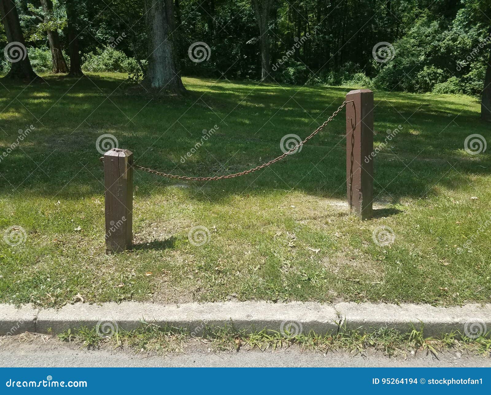 Wood Posts Connected with a Chain in the Grass Stock Photo - Image of ...
