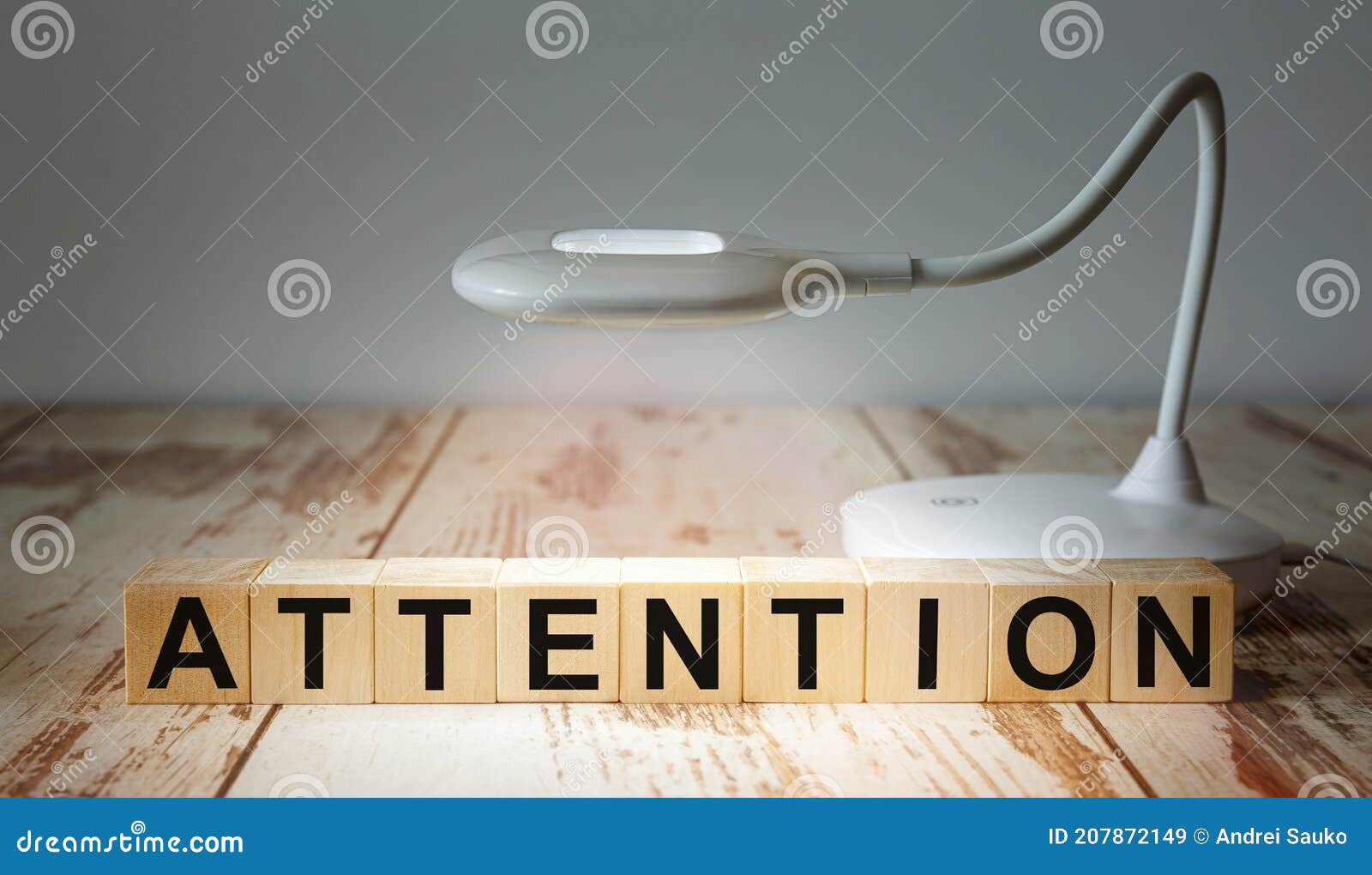 Wooden Blocks with the Word ATTENTION are Illuminated by a Table Lamp ...