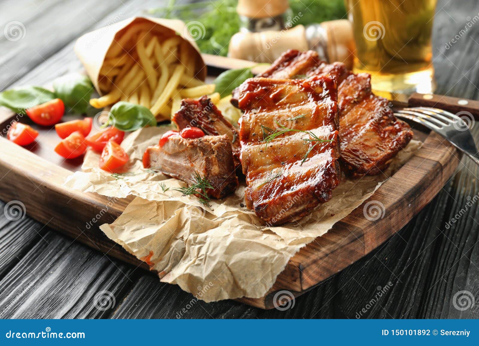 Wooden Board with Delicious Grilled Ribs on Table Stock Photo - Image ...