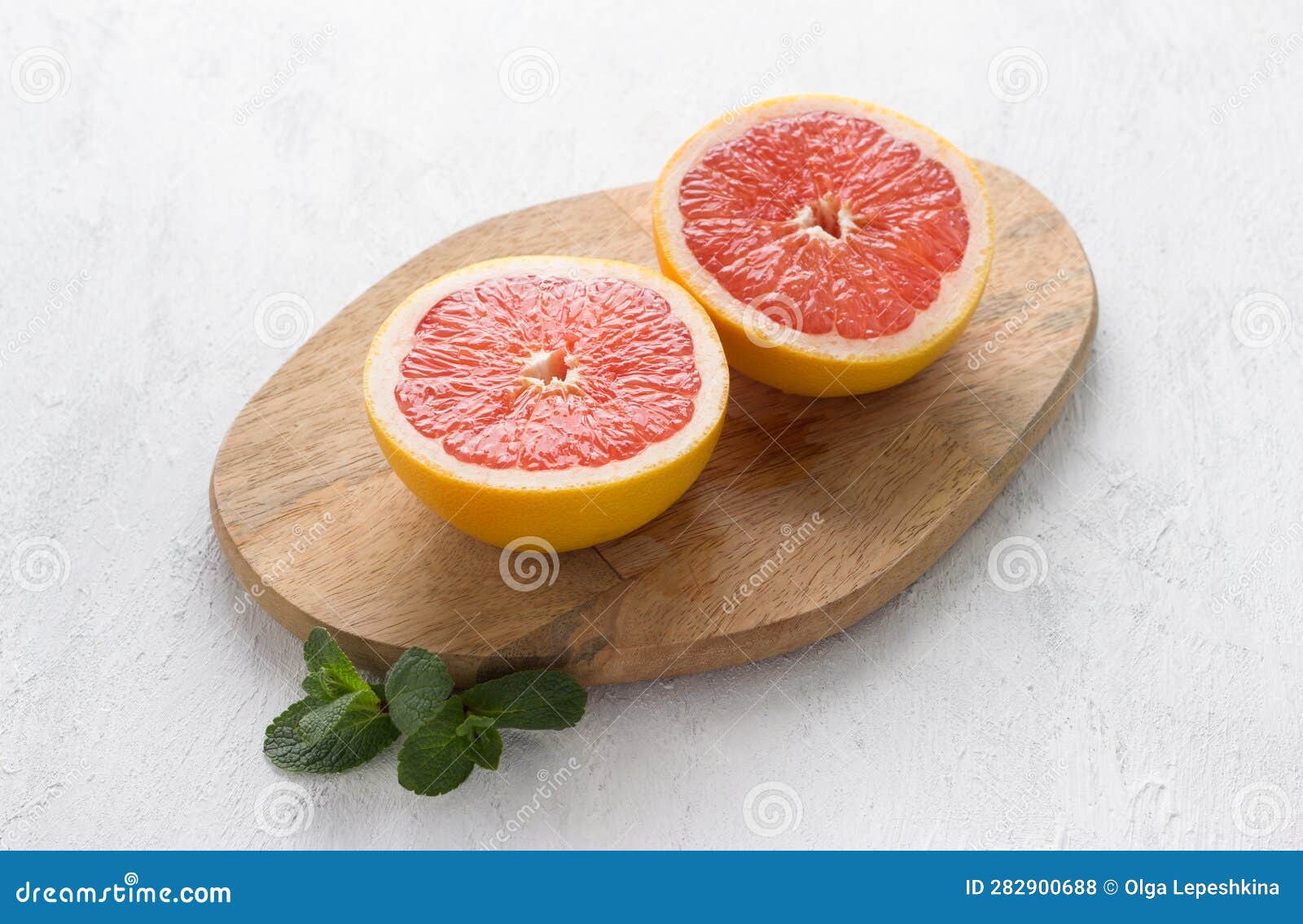 Wooden Board with Two Halves of a Grapefruit on a Light Gray Background ...