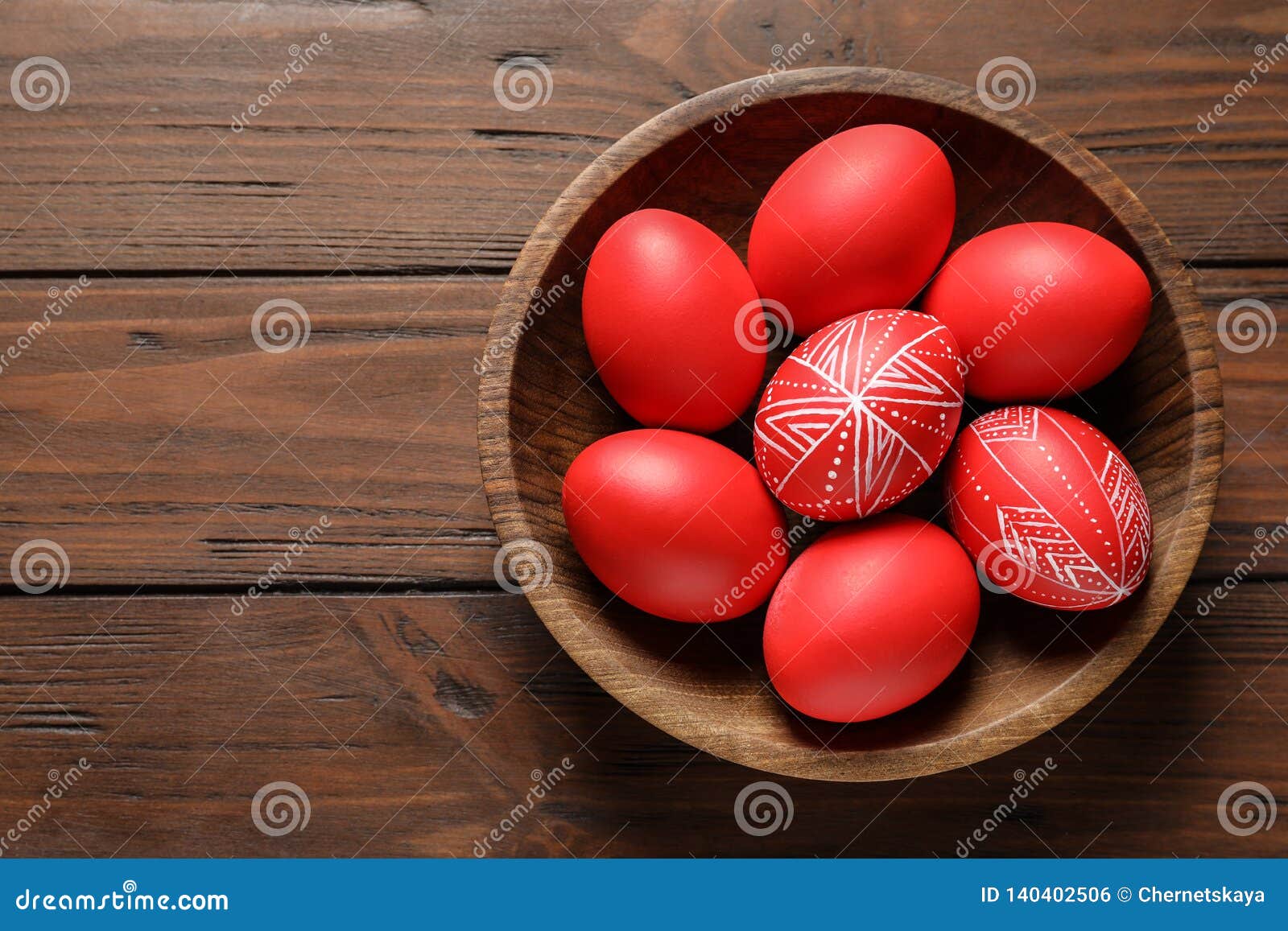 Wooden Bowl with Painted Red Easter Eggs on Table, Top View. Stock ...