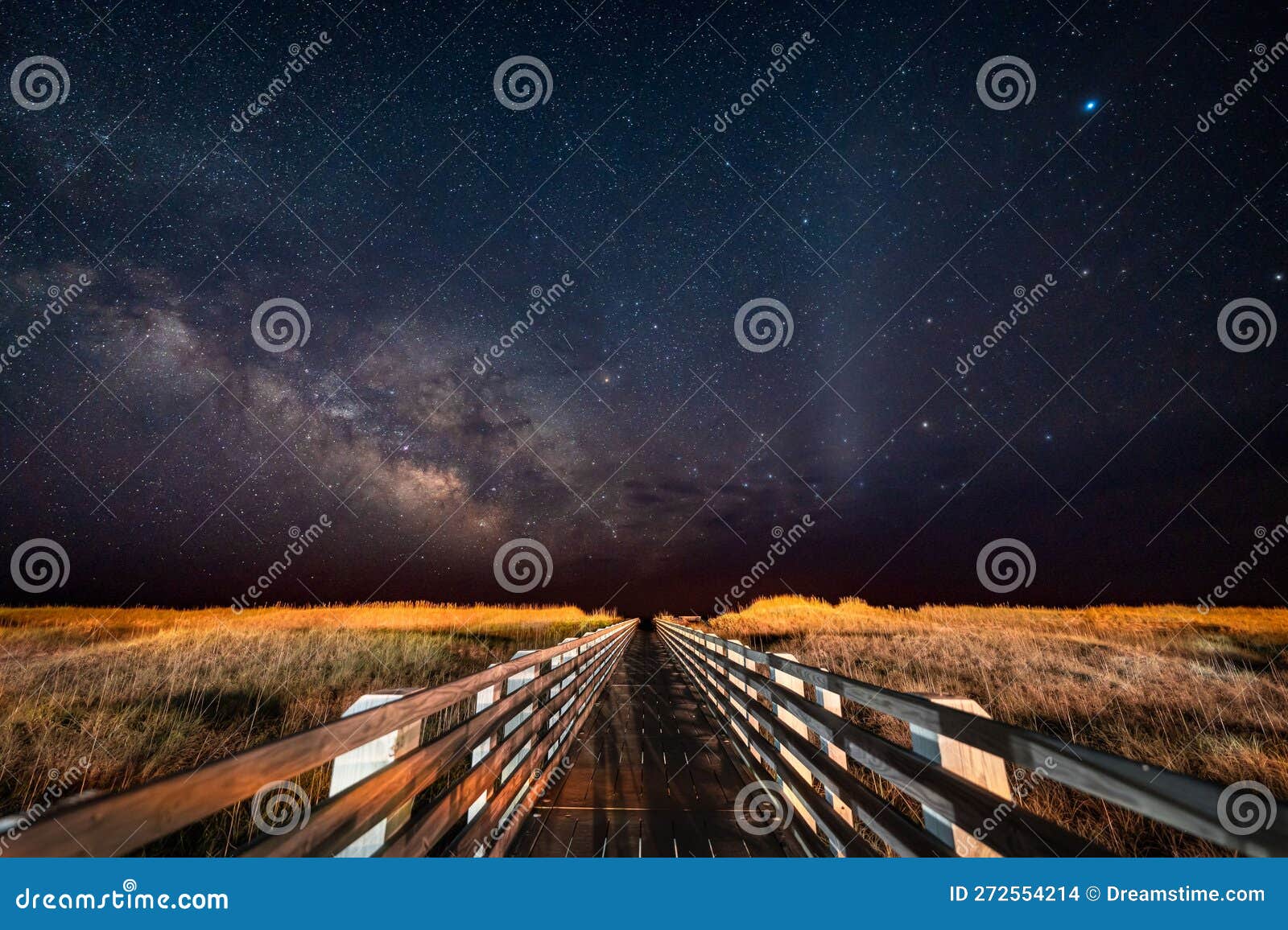 Wooden Bridge Illuminated by Moonlight and Starry Night Across a Meadow ...