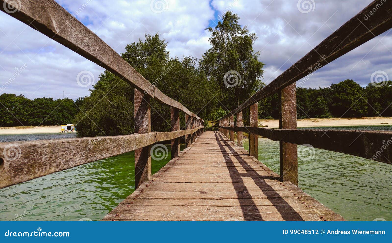 Wooden bridge over a lake stock photo. Image of beach - 99048512