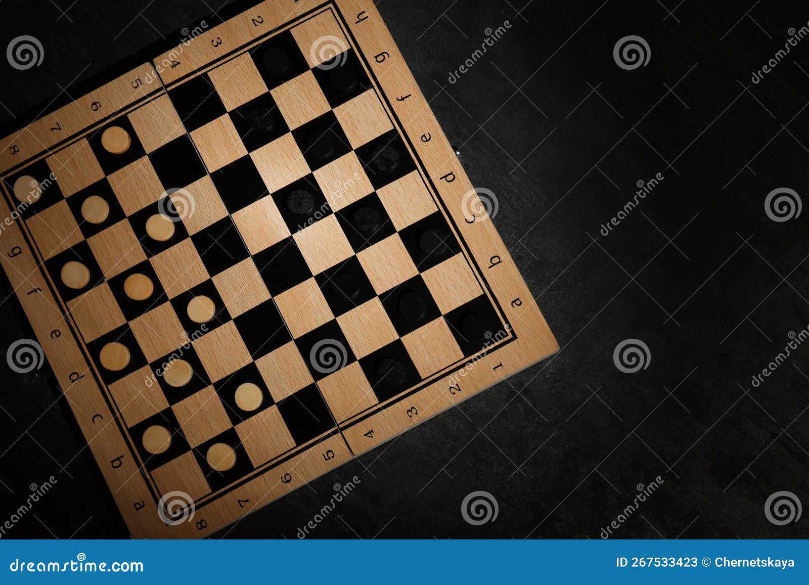 Wooden Checkerboard with Game Pieces on Black Table, Top View. Space ...