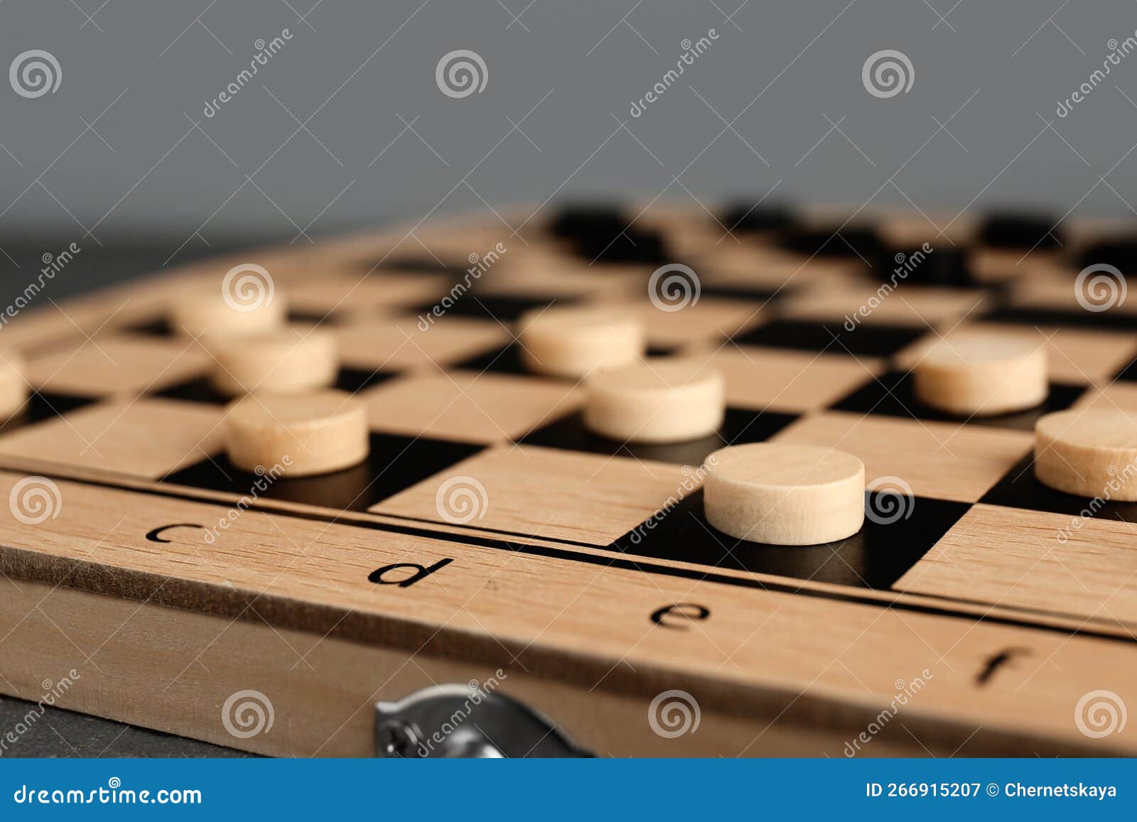 Wooden Checkerboard with Game Pieces on Light Grey Background, Closeup ...