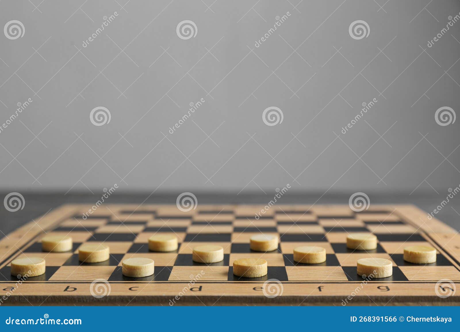 Wooden Checkerboard with Game Pieces on Light Grey Background, Closeup ...