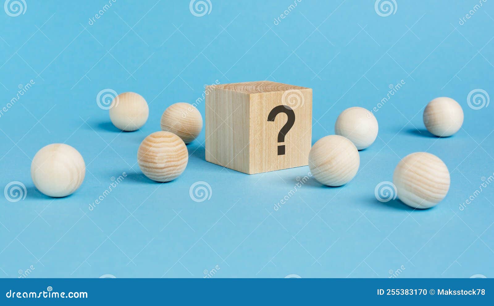Wooden Cube with a Question Mark Surrounded by Wooden Balls on a Blue ...