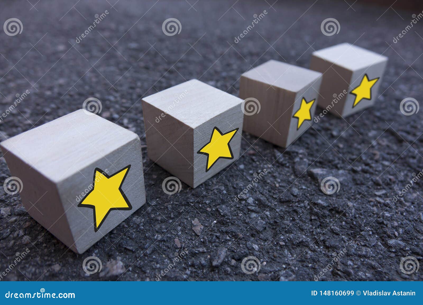 4 Wooden Cubes with a Pattern of a Yellow Star Standing on Top of Each ...