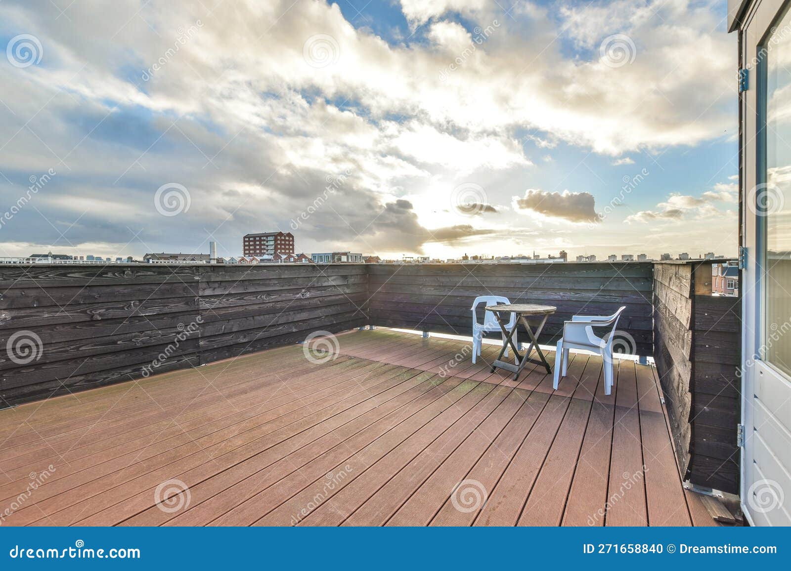 A Rooftop Deck with a Table and Chairs on it Stock Photo - Image of ...