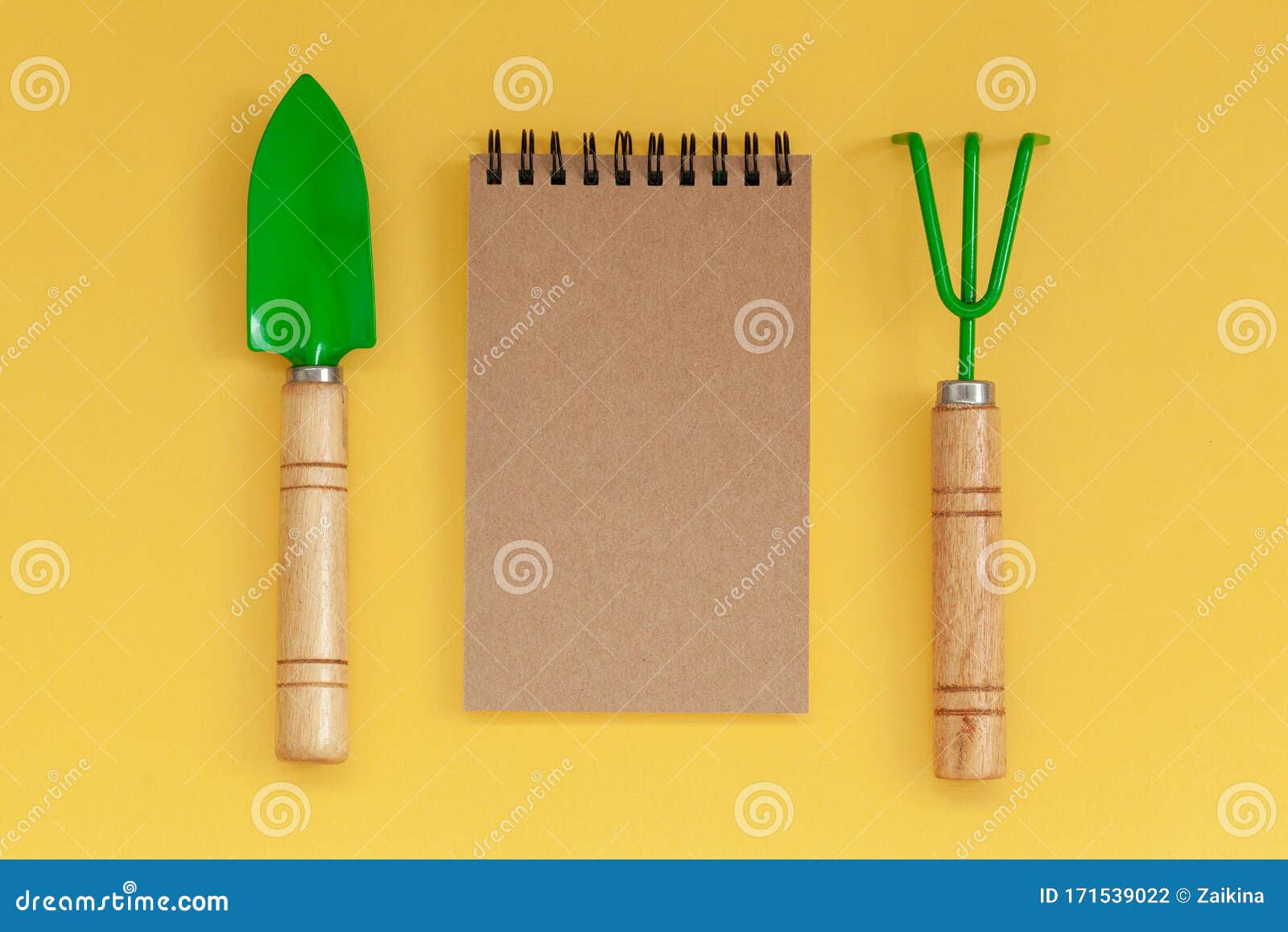 Wooden Handled Garden Hand Trowel and Hand Fork and Empty Noteboook on ...