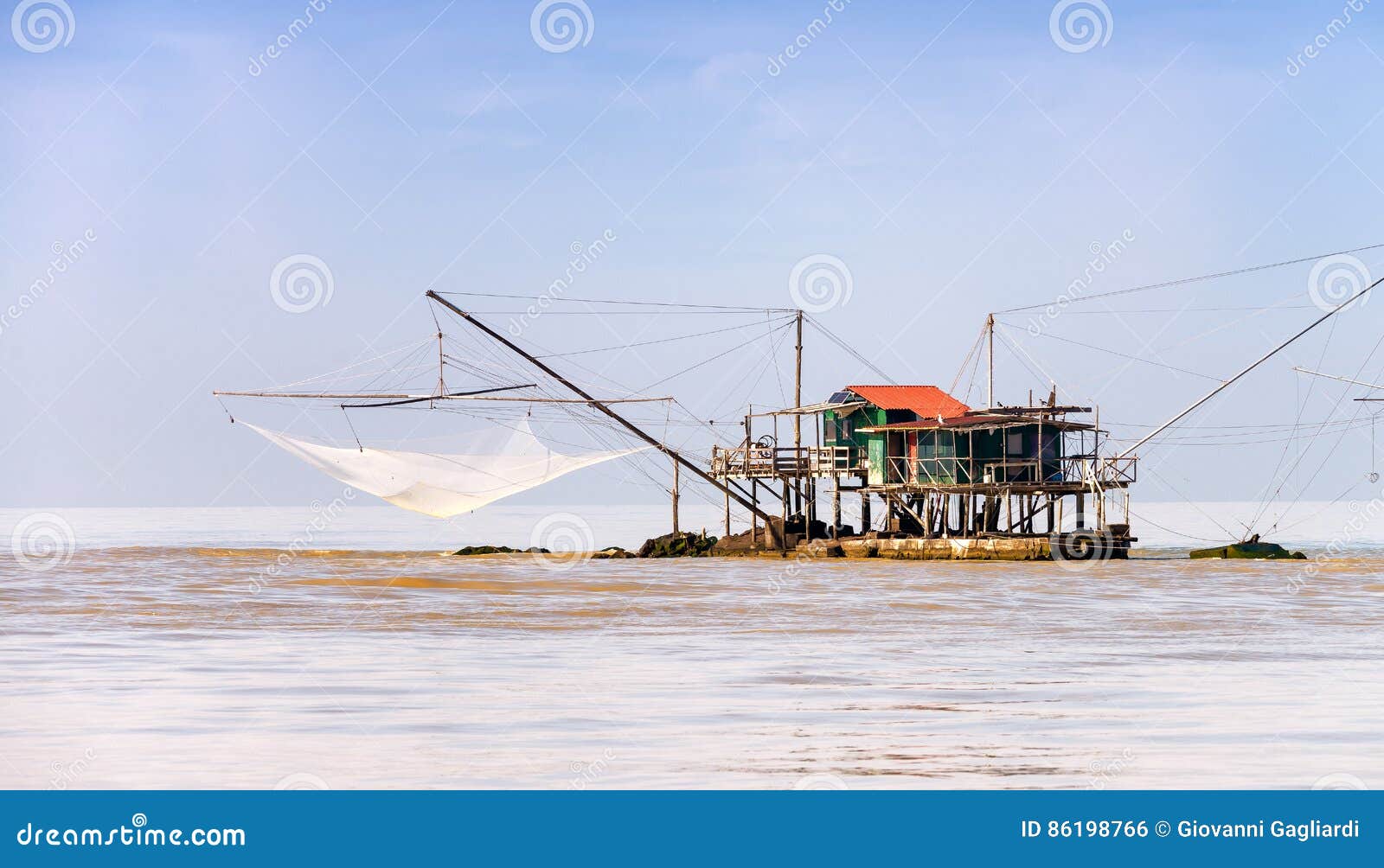 Wooden House in the Middle of the Sea Over Rocks Stock Photo - Image of ...