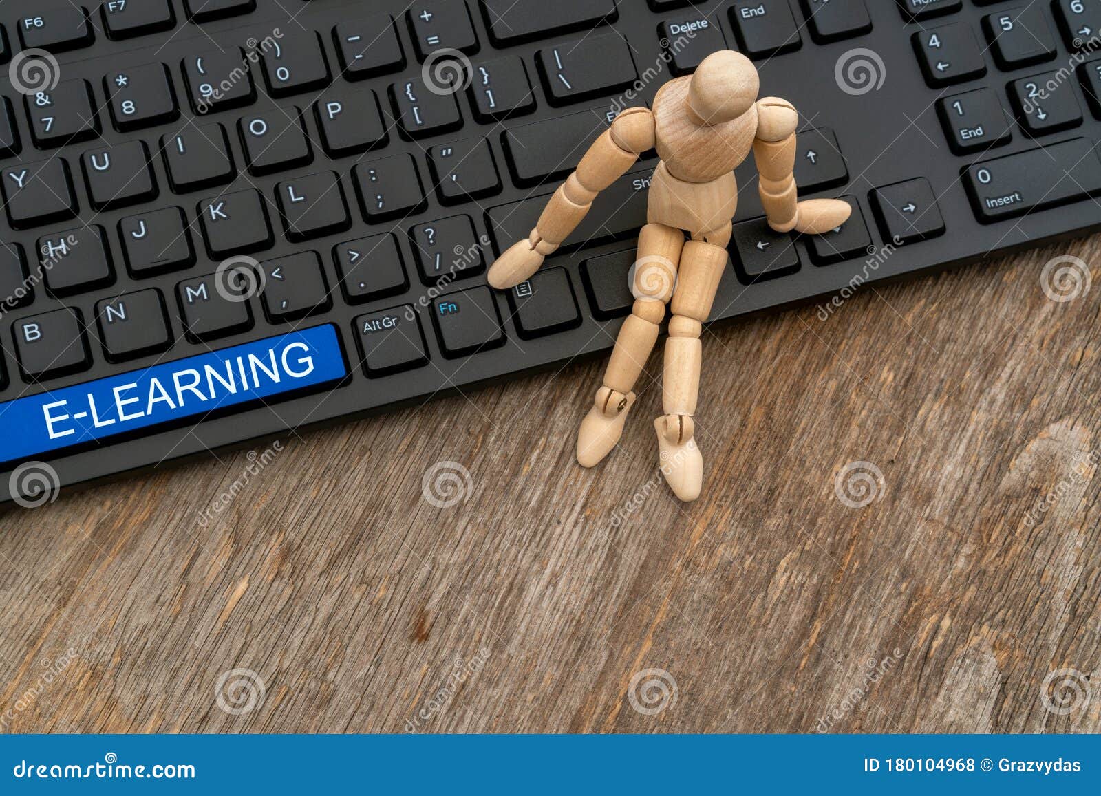 Wooden Man Sitting on the Keyboard with E-learning Button Stock Photo ...
