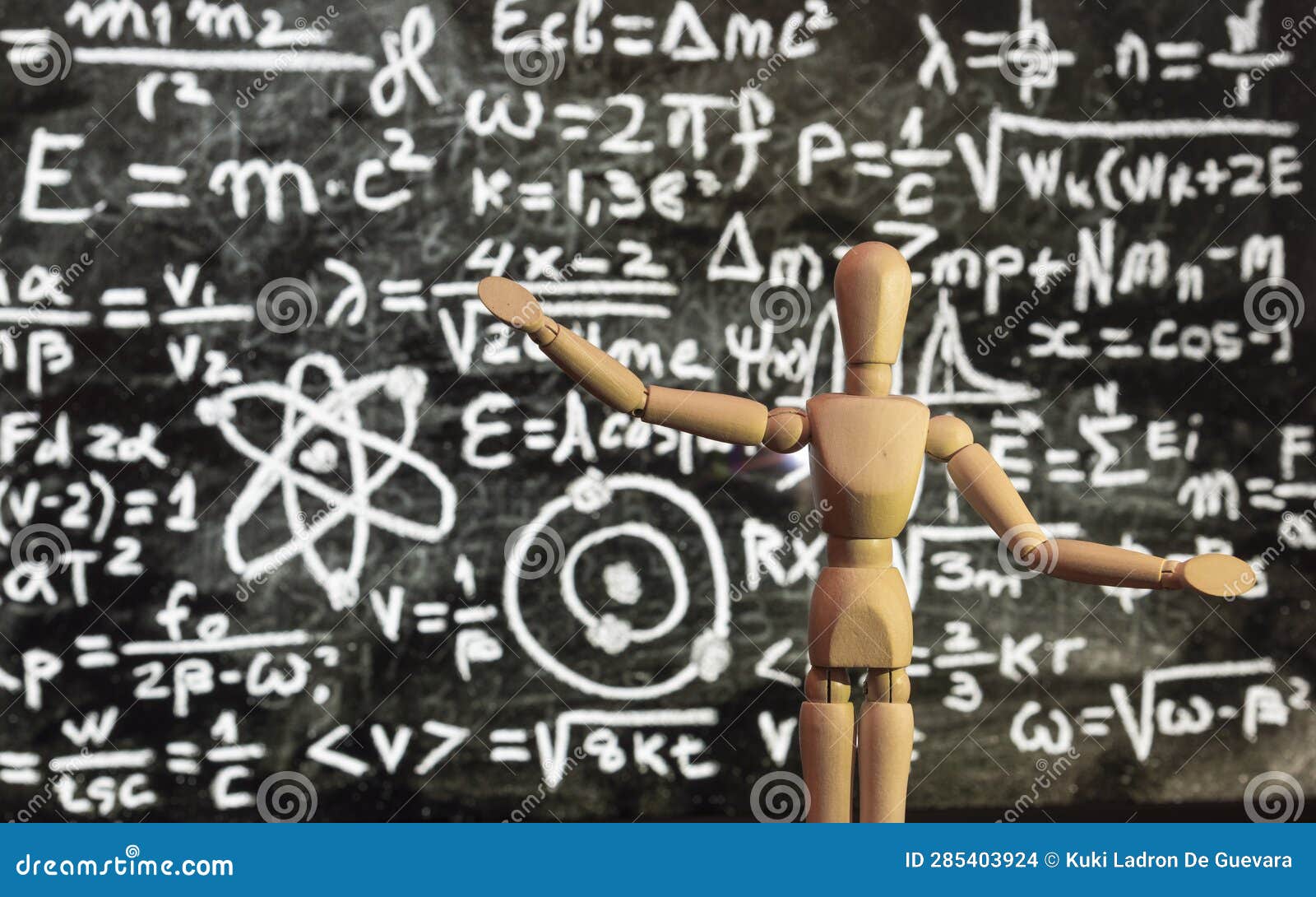Wooden Mannequin in Front of a Blackboard Written with Mathematical ...