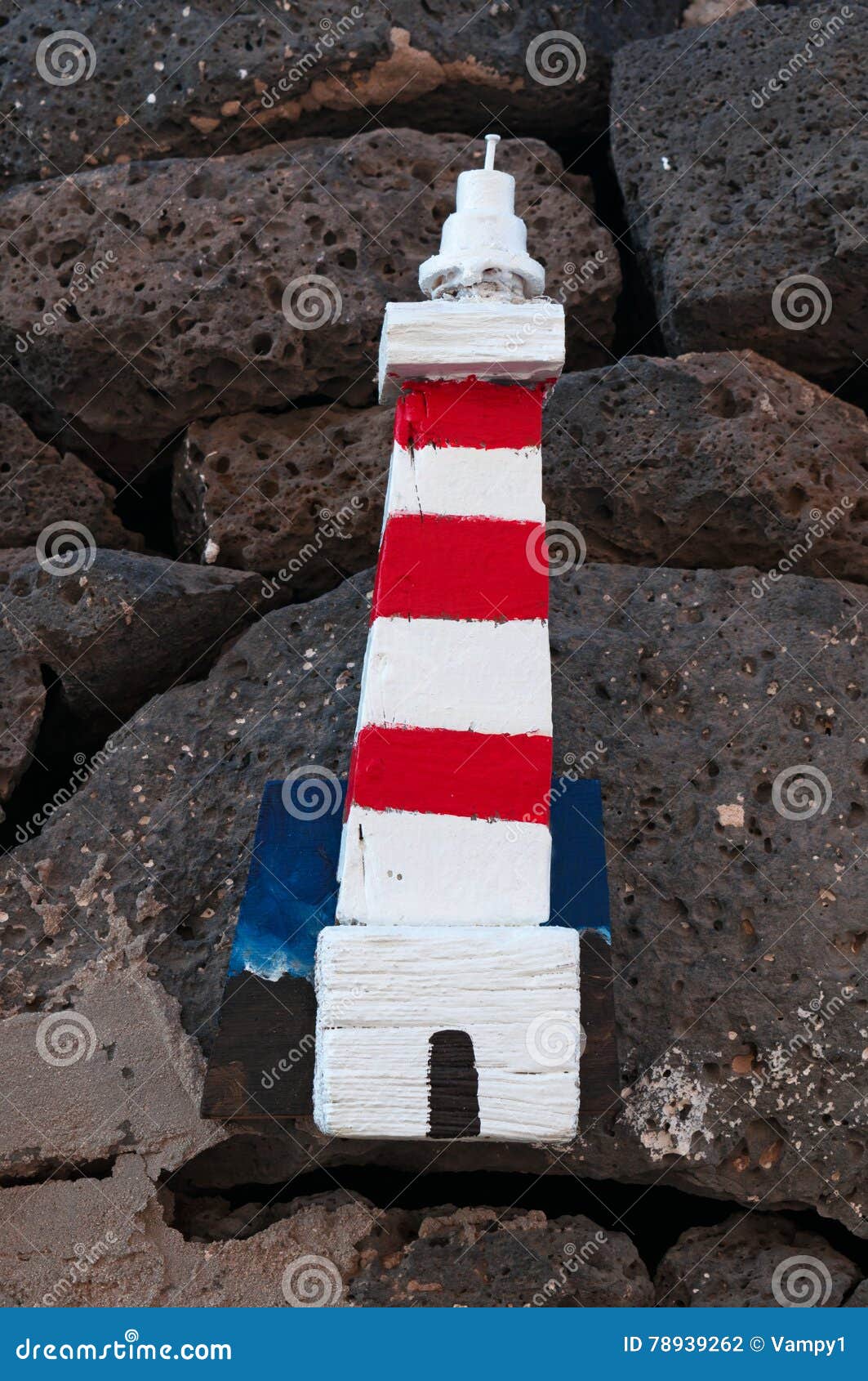 A Wooden Panel with a Lighthouse Hanging on Black Rocks Stock Photo ...