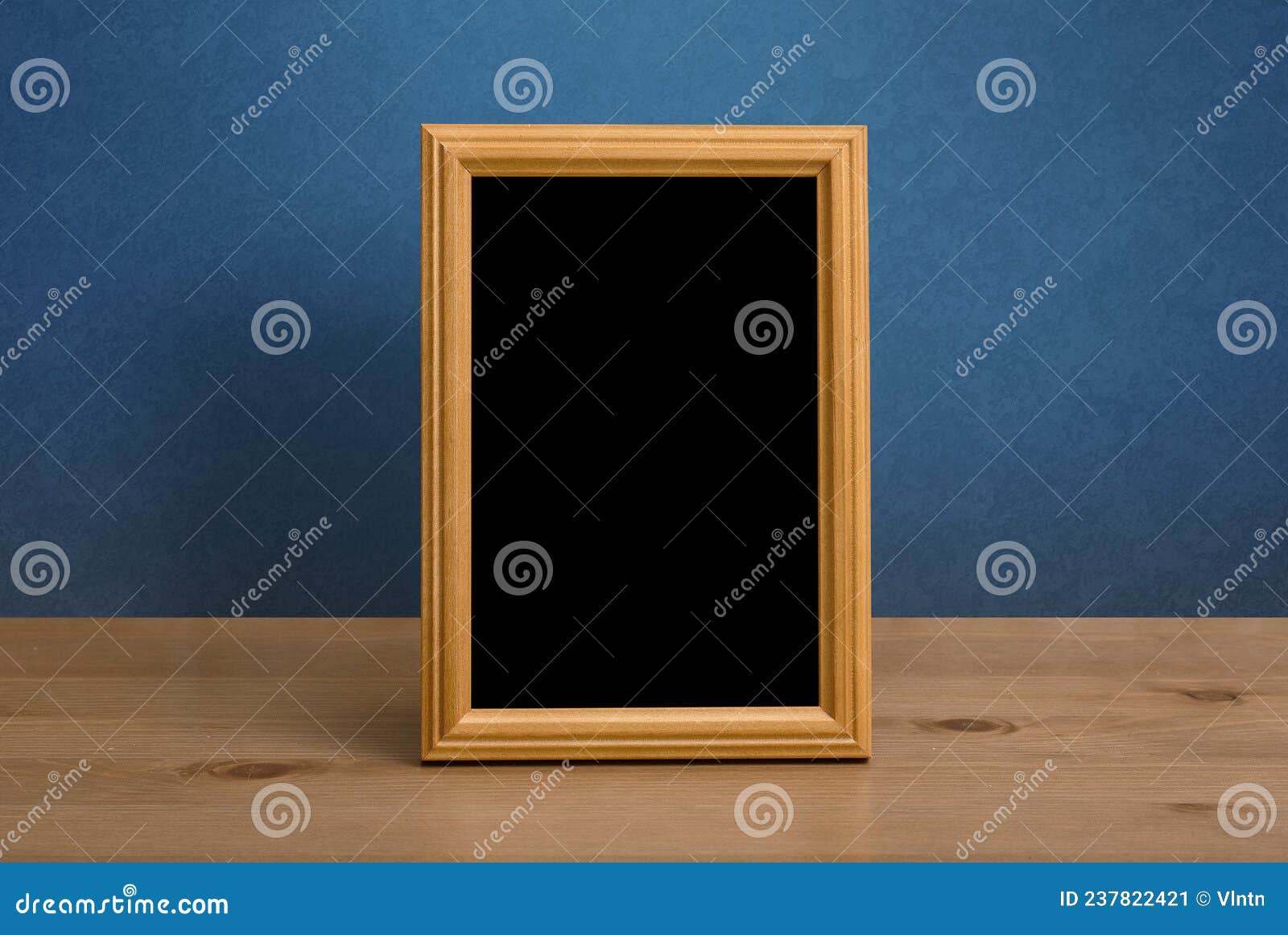 Frame on table, blue wall stock image. Image of room - 237822421
