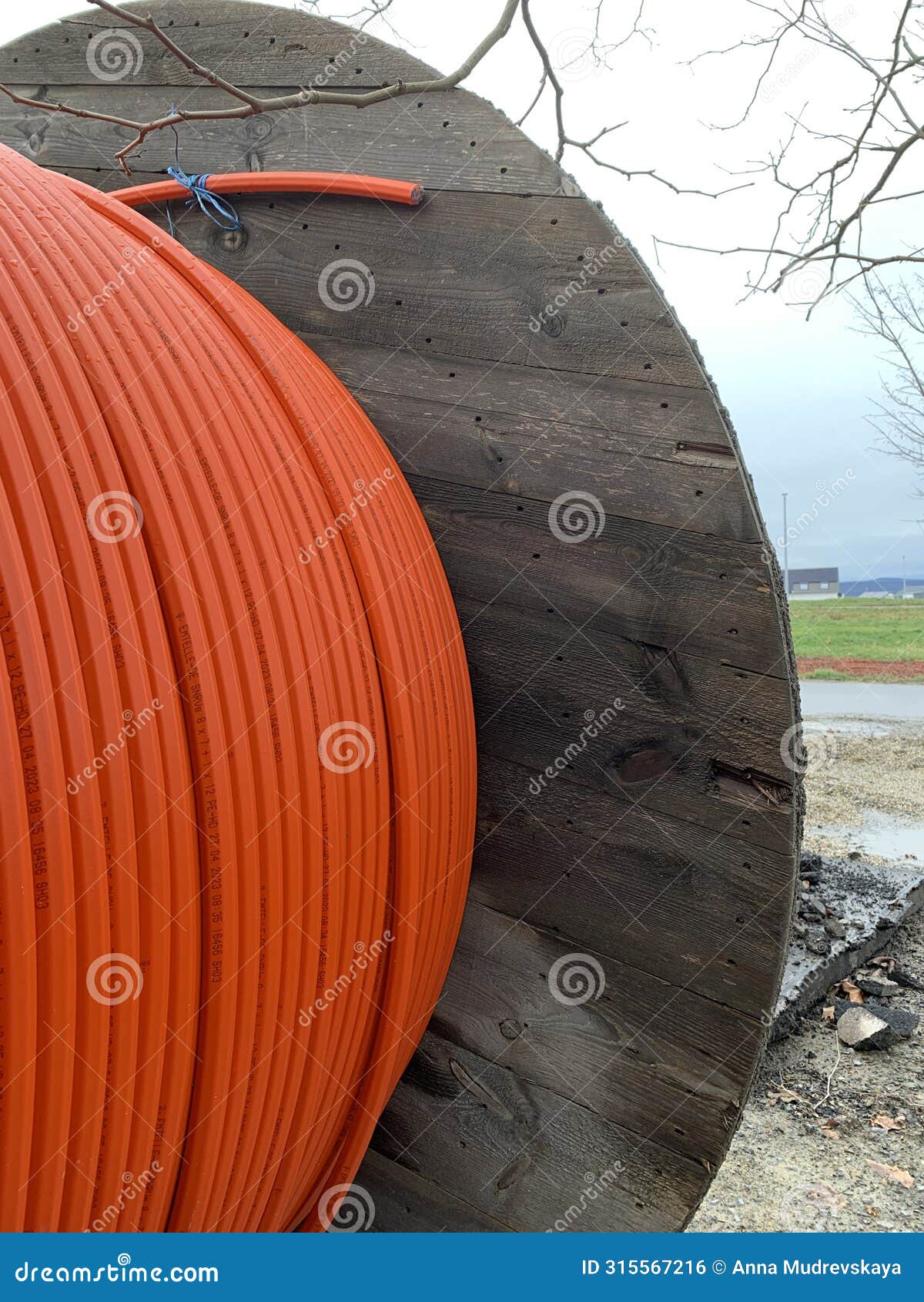 A Wooden Reels with an Orange Cable on a Construction Site. Side View ...