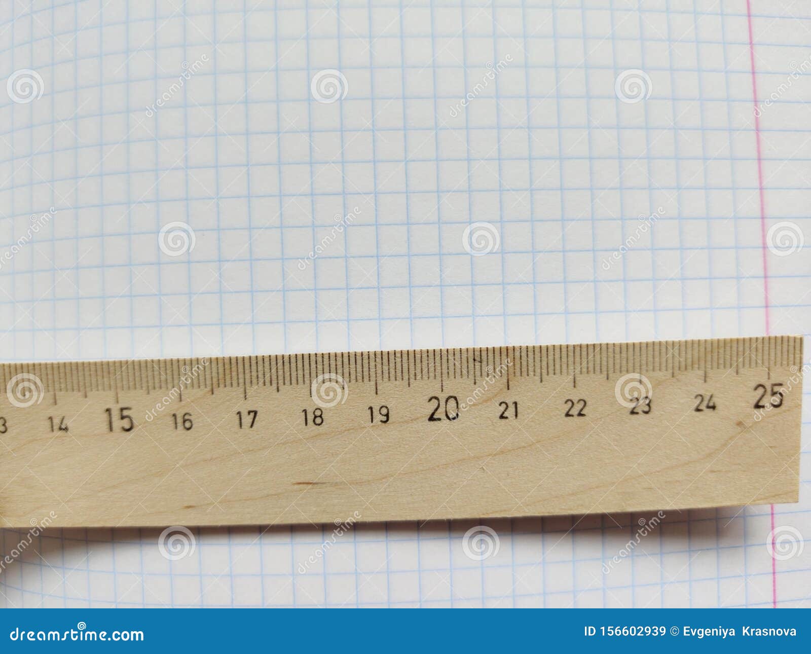 Wooden Ruler with Metric System Rests on a White Checkered Exercise ...