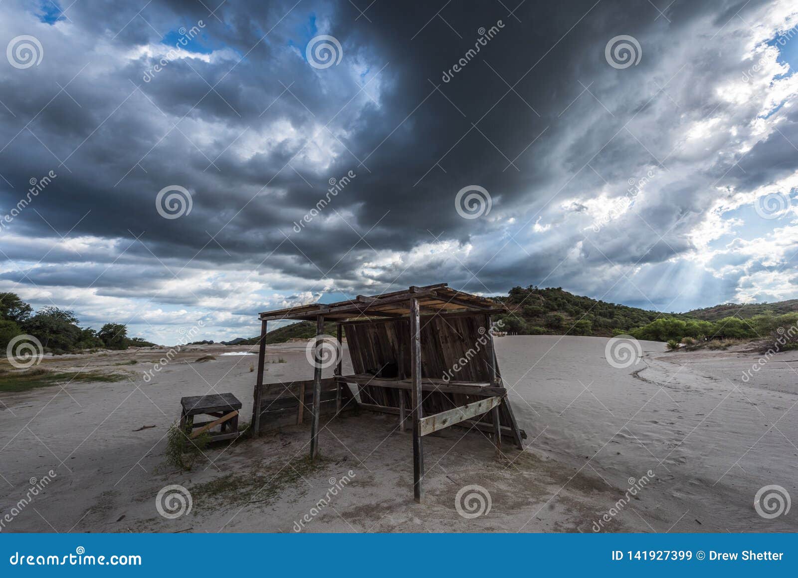 Wooden Shack with Dramatic Clouds and Sunbeam in Background Stock Image ...