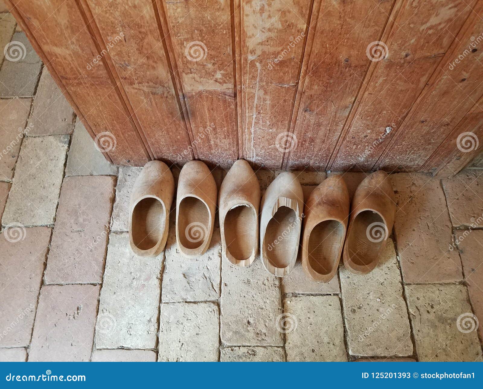 Wooden Shoes on Brick Stone Floor by a Wooden Wall Stock Image - Image ...